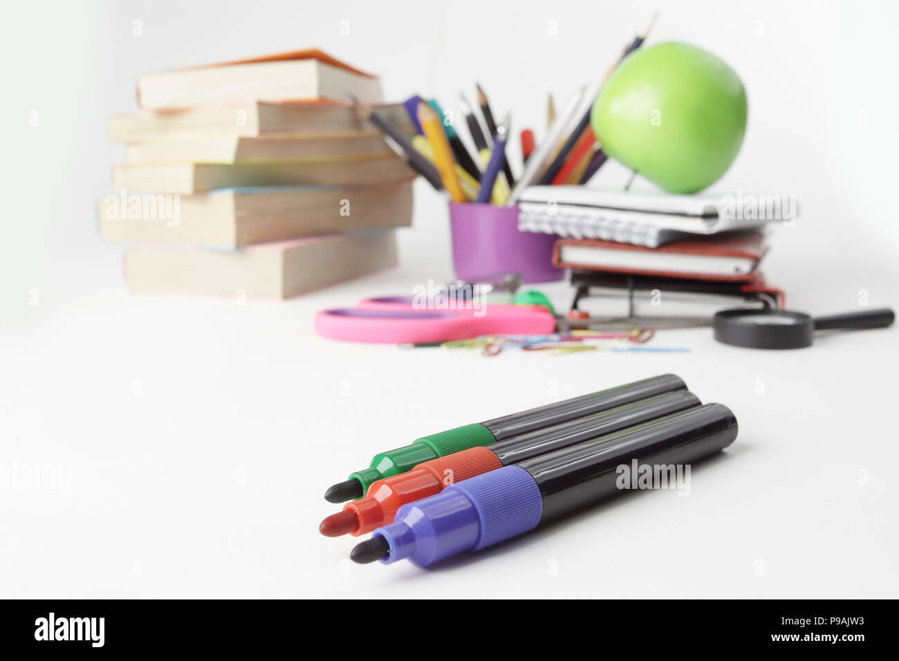 colored markers and school supplies on a white background .concept of ...