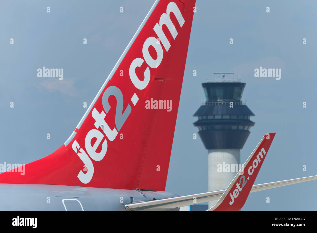 The tailfin of an Jet2 Boeing 737 taxiing along the runway in front of ...