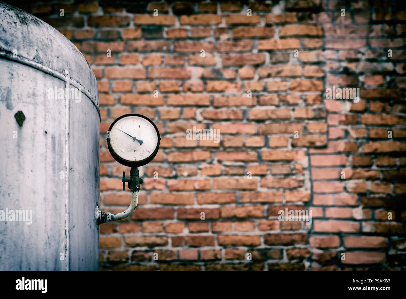 Old pressure gauge of the tank against the backdrop of a brick wall ...