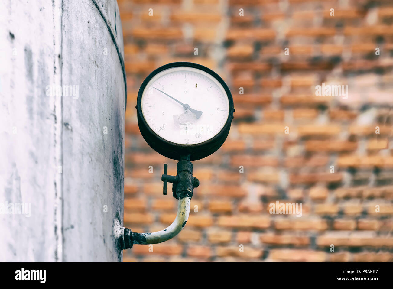 Old pressure gauge of the tank. Pressure sensor against a brick wall ...