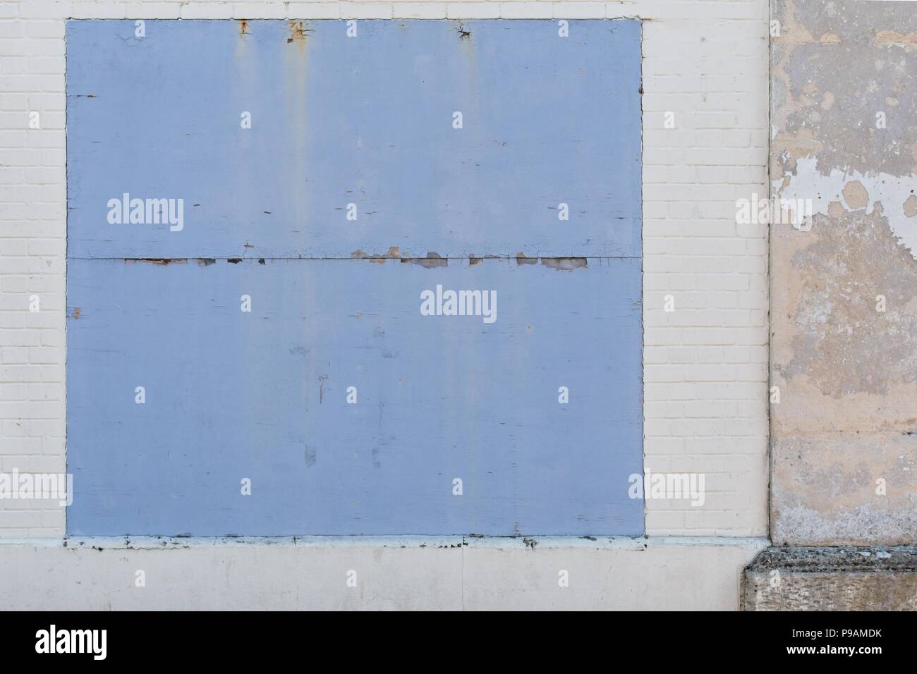 Whitwashed old brick wall with blue borded up window Stock Photo - Alamy