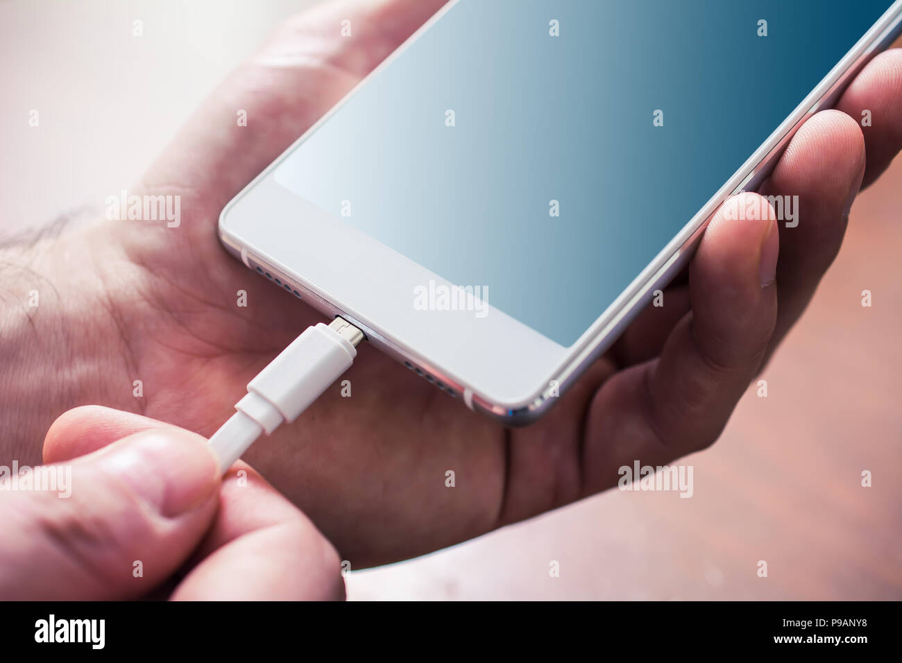 White USB Cable Connected With A White Mobile Phone, Holded By Male ...