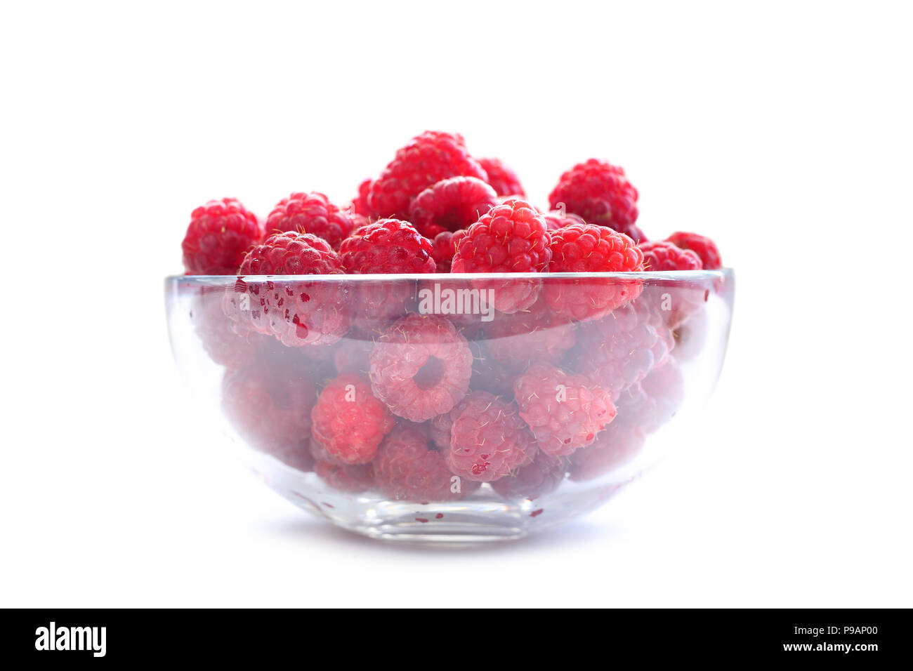 Big Pile of Fresh Raspberries in transparent bowl isolated on the white ...