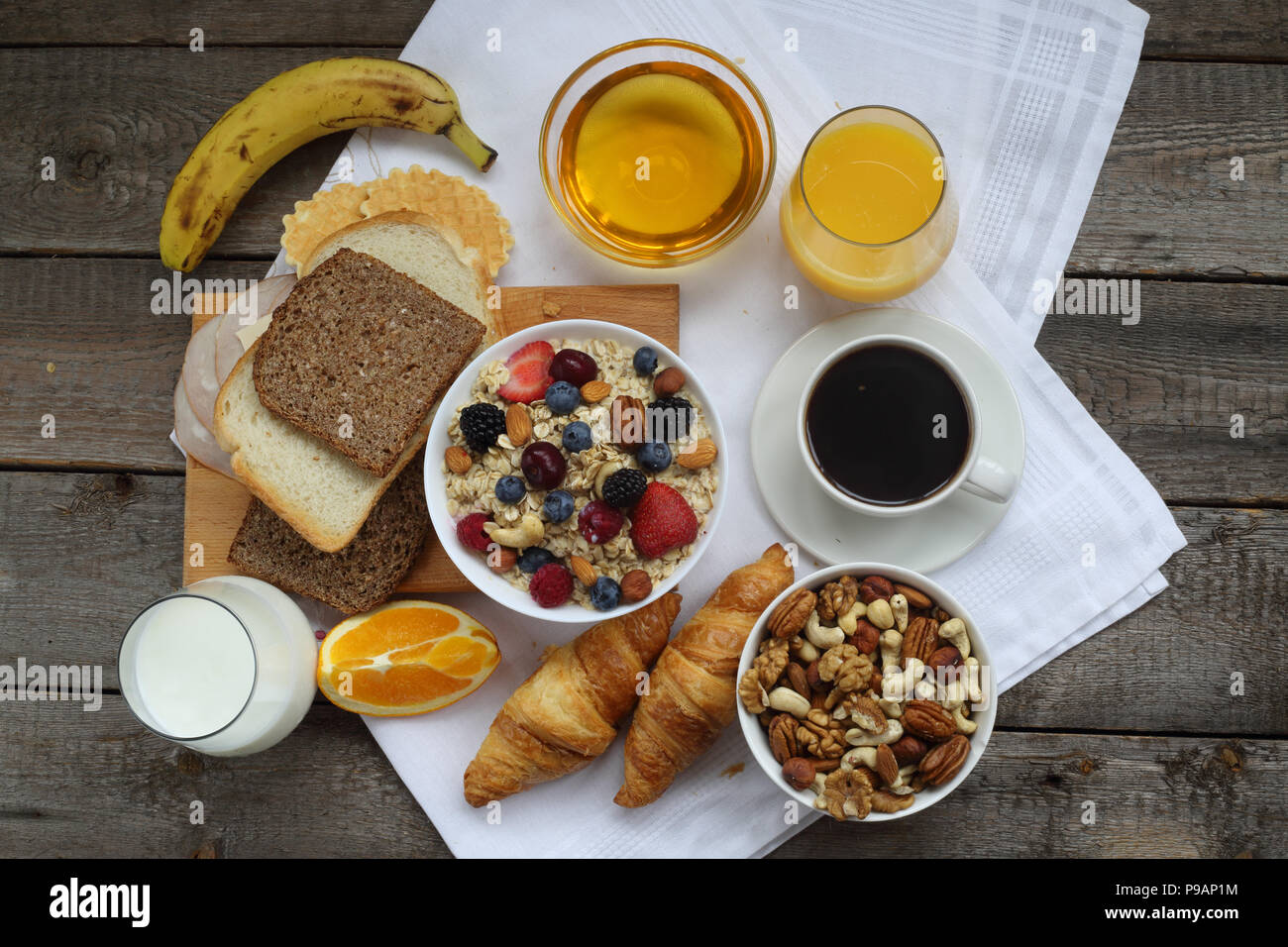 Healthy breakfast with muesli, fruits, berries, nuts, coffee, eggs ...