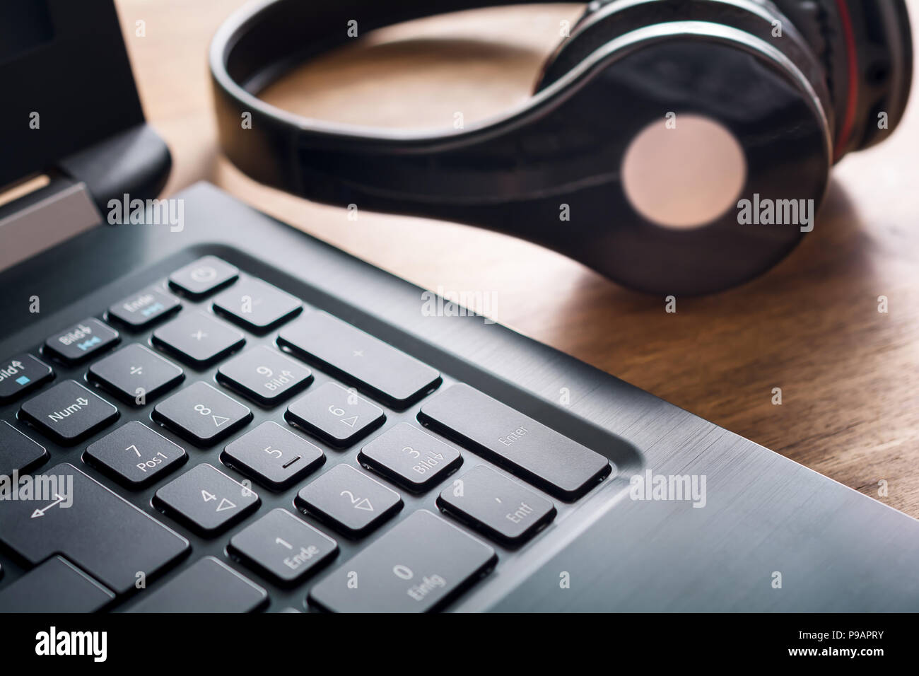 Small Black Wireless Overhead Headphone Lying Next To A The Keyboard Of ...