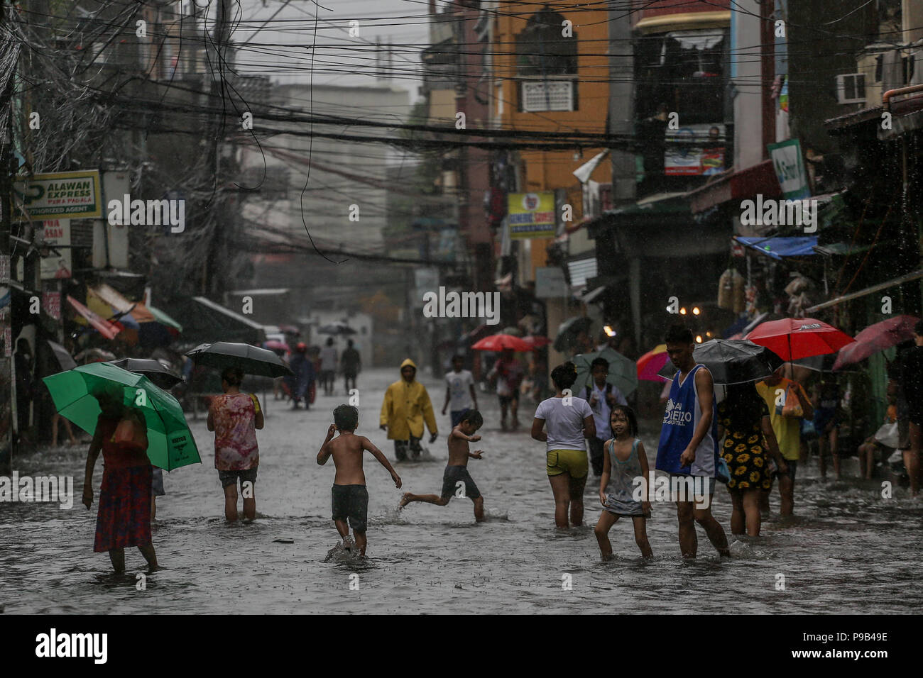 Manila, Philippines. 17th July, 2018. People walk along a flooded ...