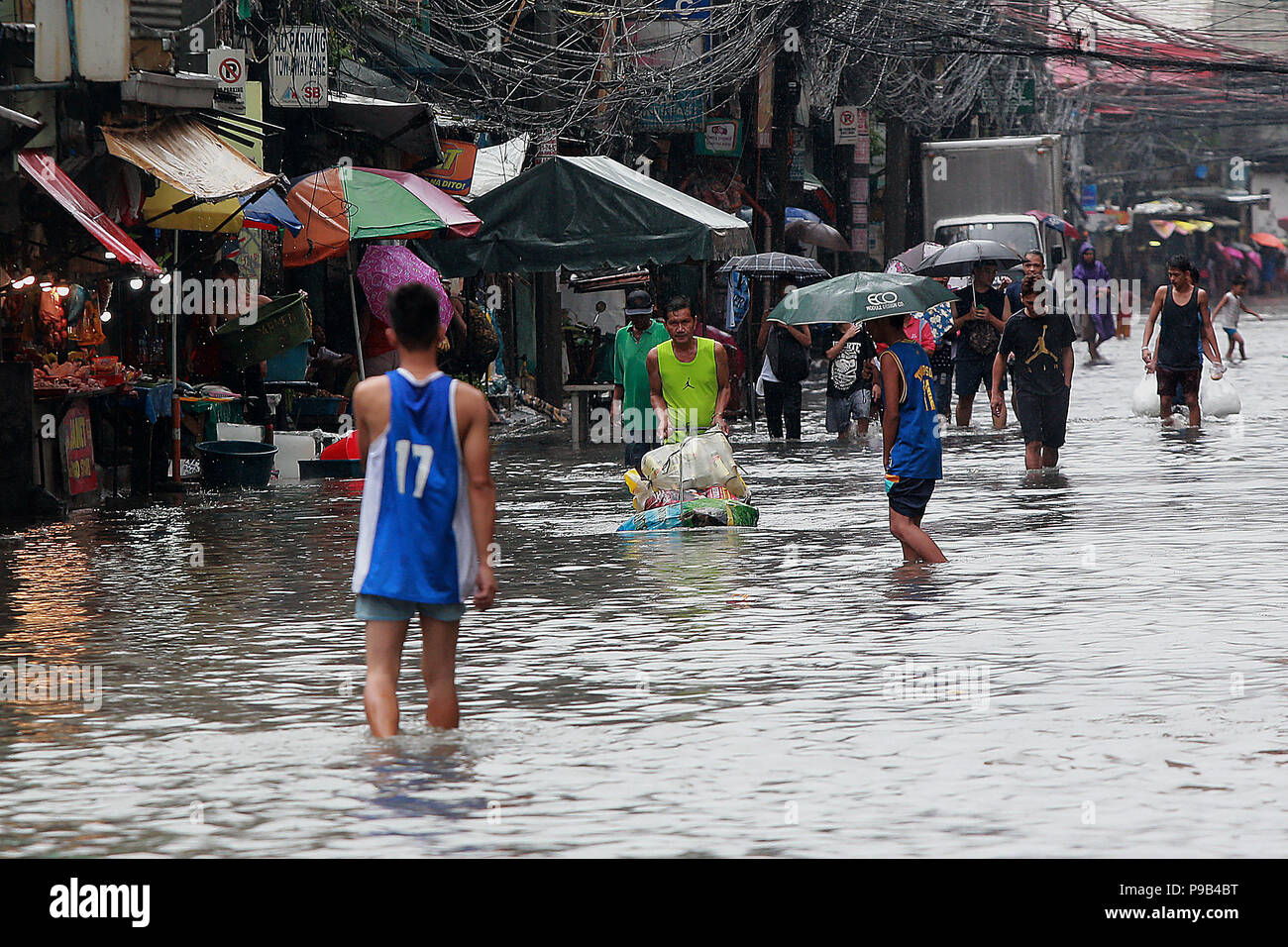 Quezon City, Philippines. 17th July, 2018. Residents wade through flood ...