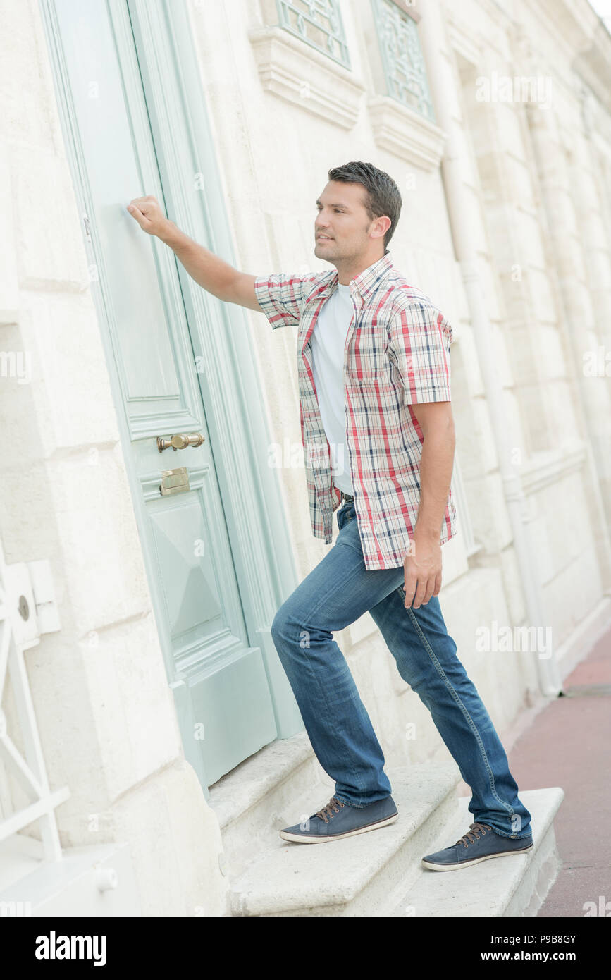 Man knocking at a door arrive Stock Photo - Alamy