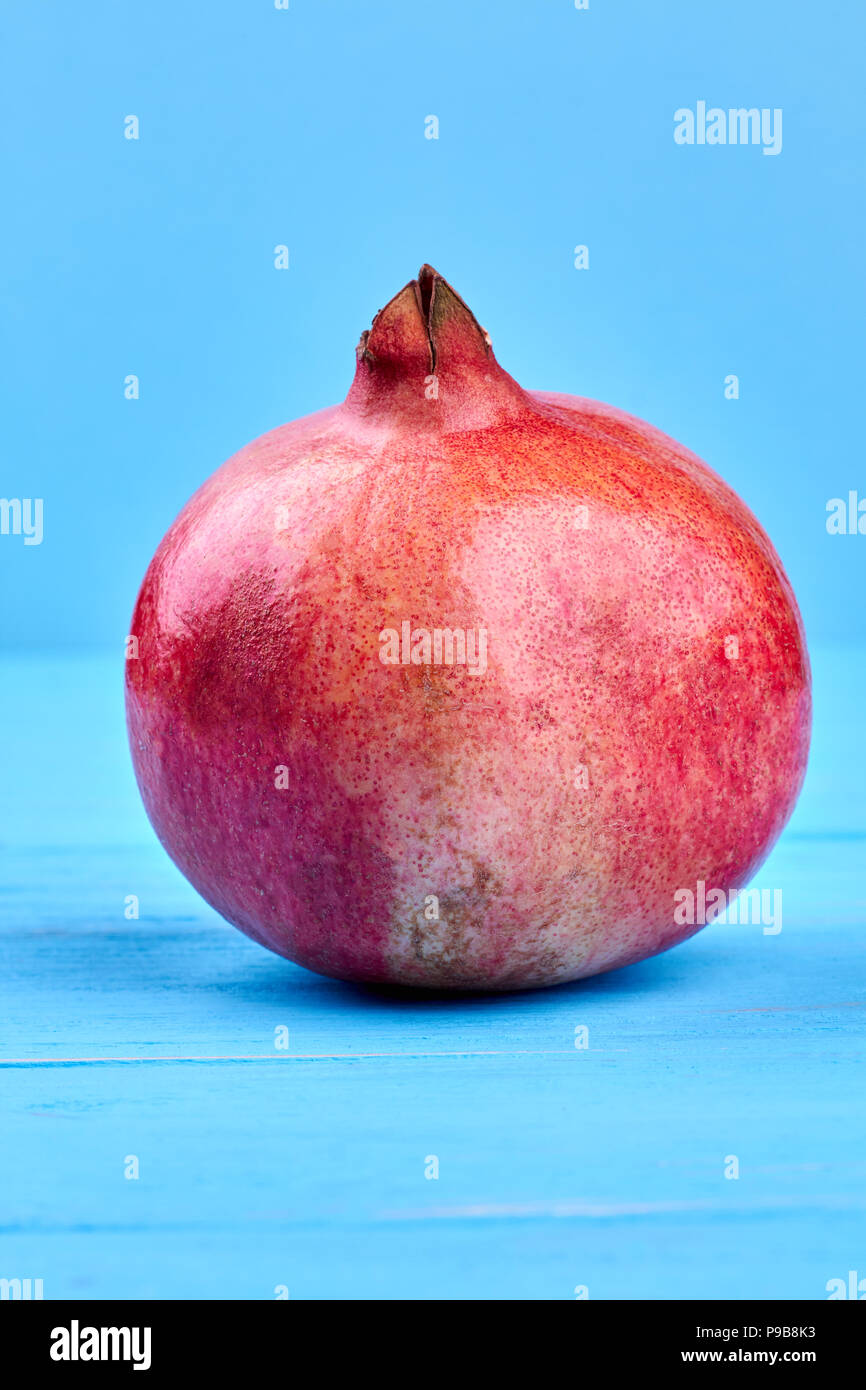Ripe healthy pomegranate on blue background. Whole fresh pomegranate on ...