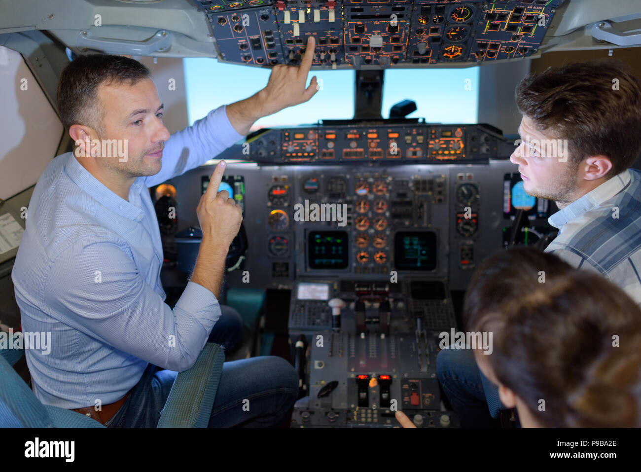 Man showing cockpit controls to young people Stock Photo - Alamy