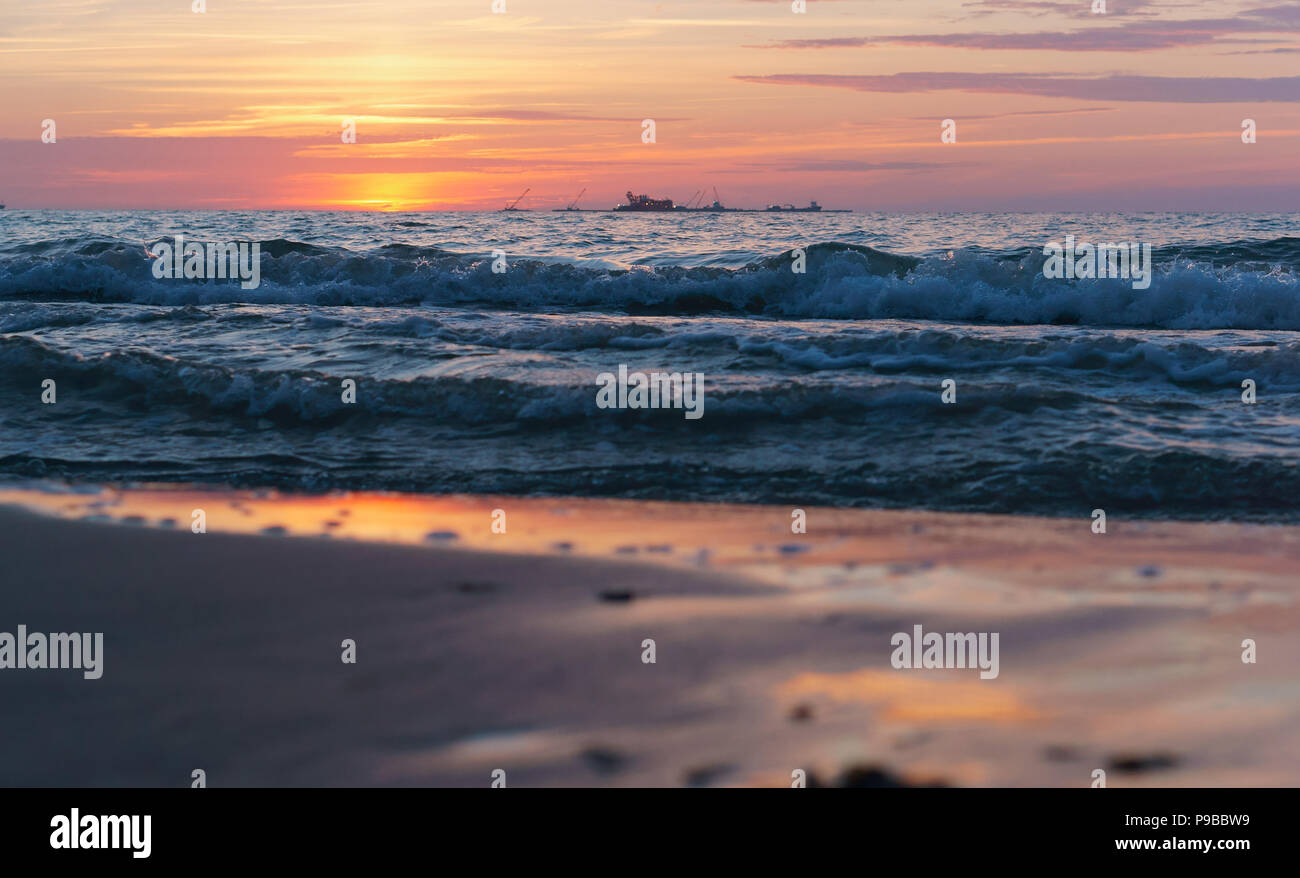 Sunset over the sea. Reflection of sunlight in the sea waves. Red sky ...