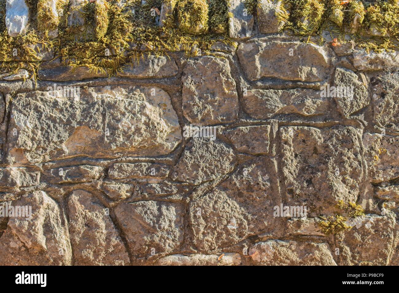Sandstone wall with moss in sunshine Stock Photo - Alamy