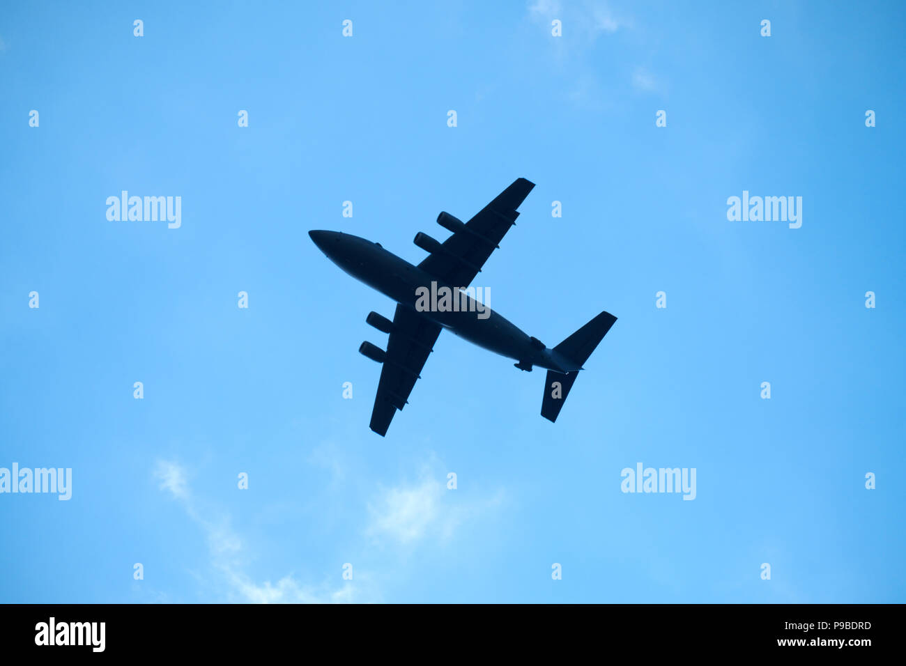 Underside of jet airplane against a blue sky Stock Photo - Alamy