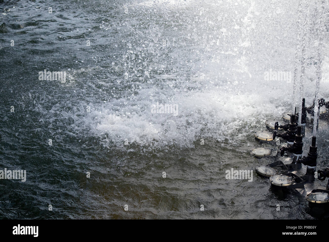 Fountain injectors and water jets gushing upwards and falling down into ...