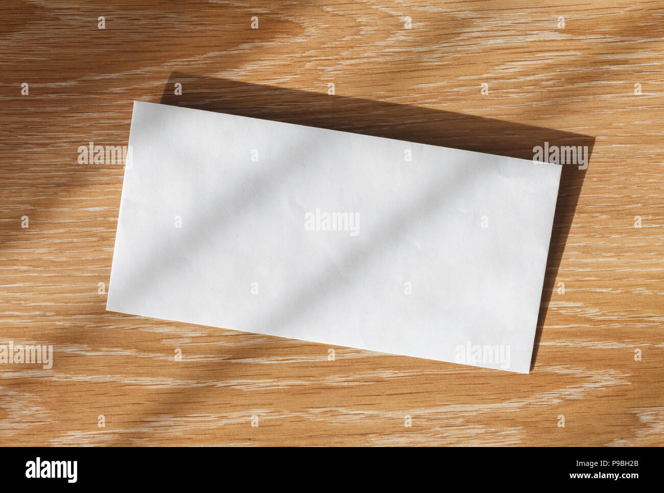 Back side of blank envelope on wooden background in sun rays Stock ...