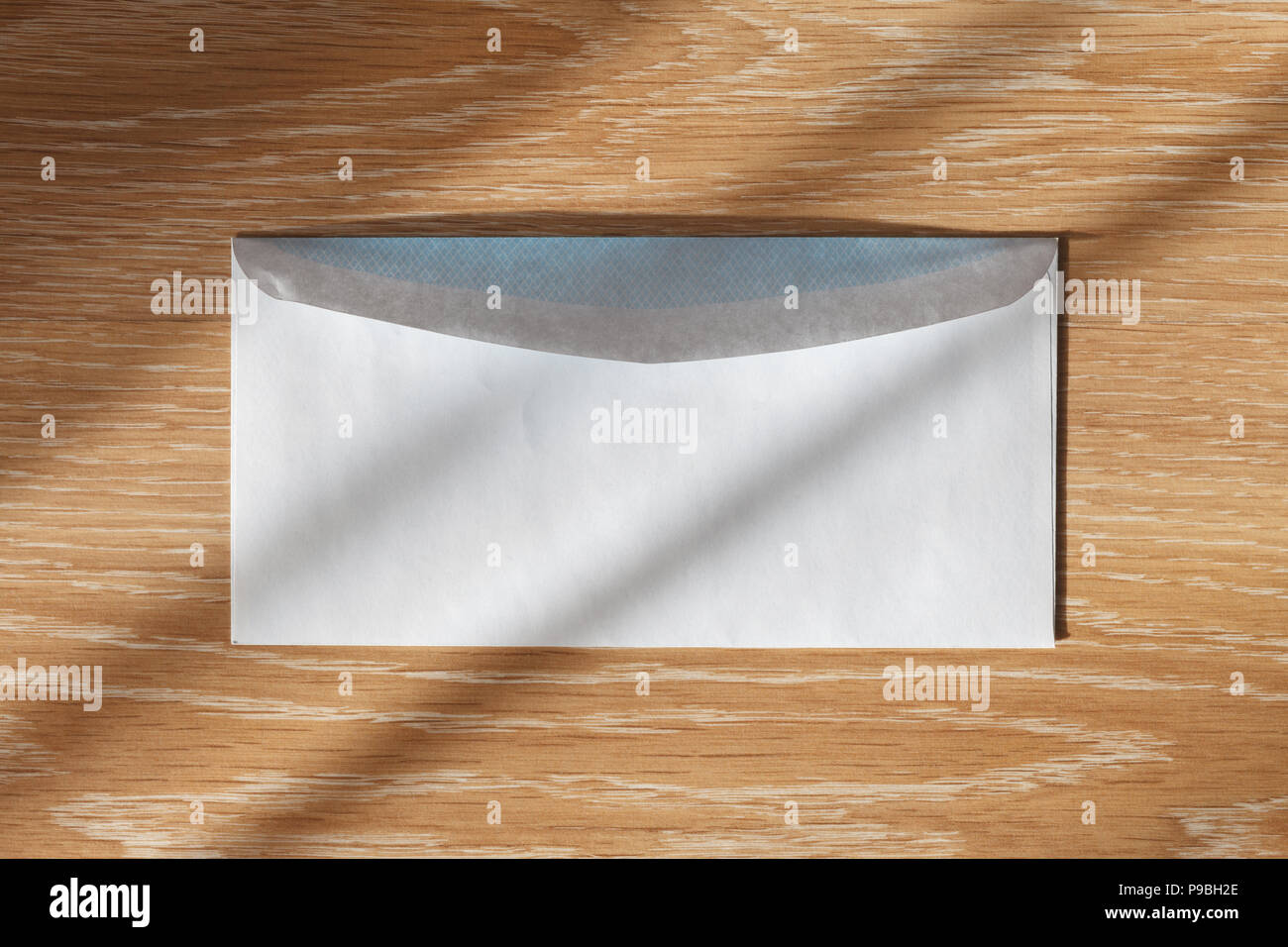Back side of blank envelope on wooden background in sun rays Stock ...
