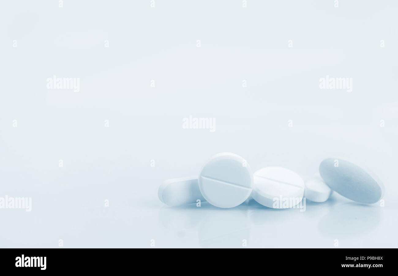 Pile of white round, oblong, and oval shape tablet pills isolated on ...