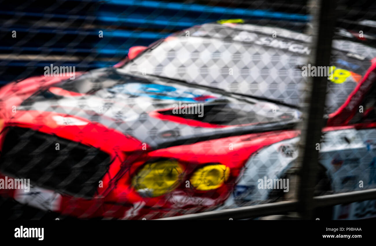 Blurred picture of fence mesh netting and car on racetrack background ...