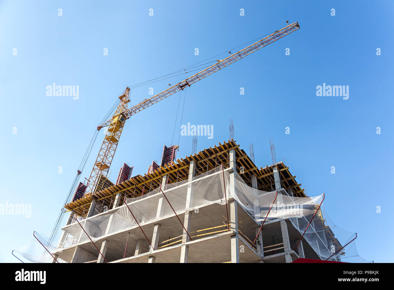 high rise construction. concrete modern building and tower crane ...