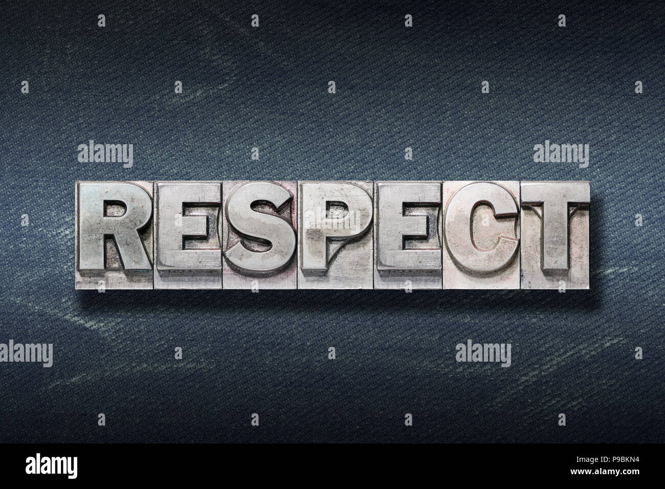 respect word made from metallic letterpress on dark jeans background ...