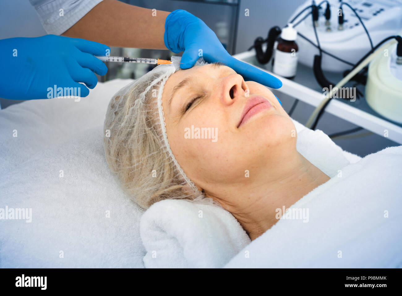 Female doctor doing beauty injection to mature woman client Stock Photo ...