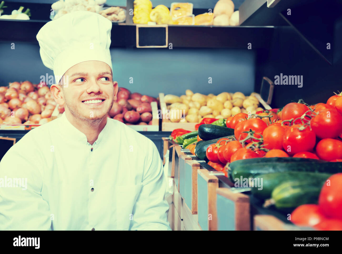 Smiling male chef looking for a fresh vegetables at grocery shop Stock ...