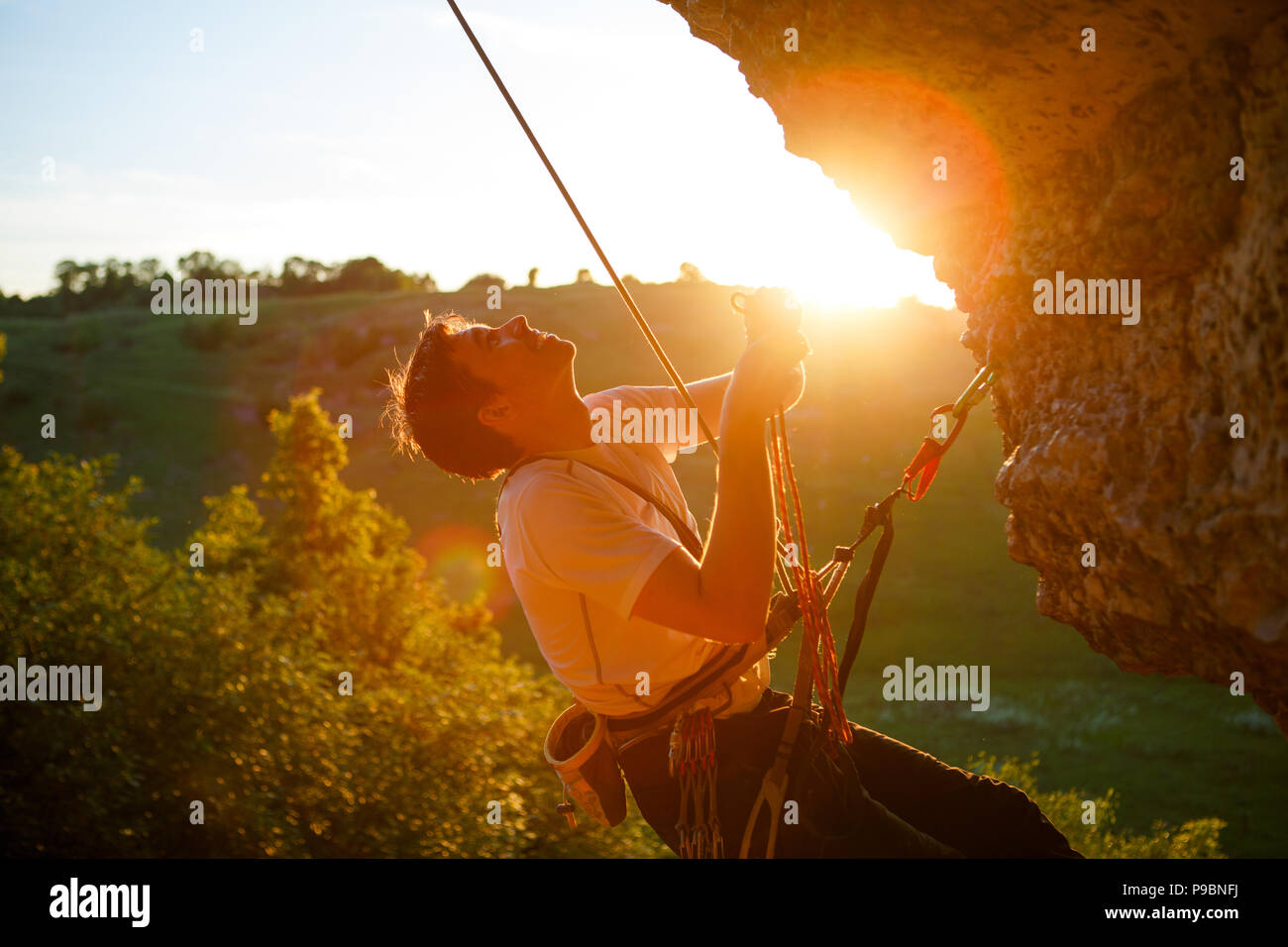 Picture of man clambering over rock Stock Photo - Alamy