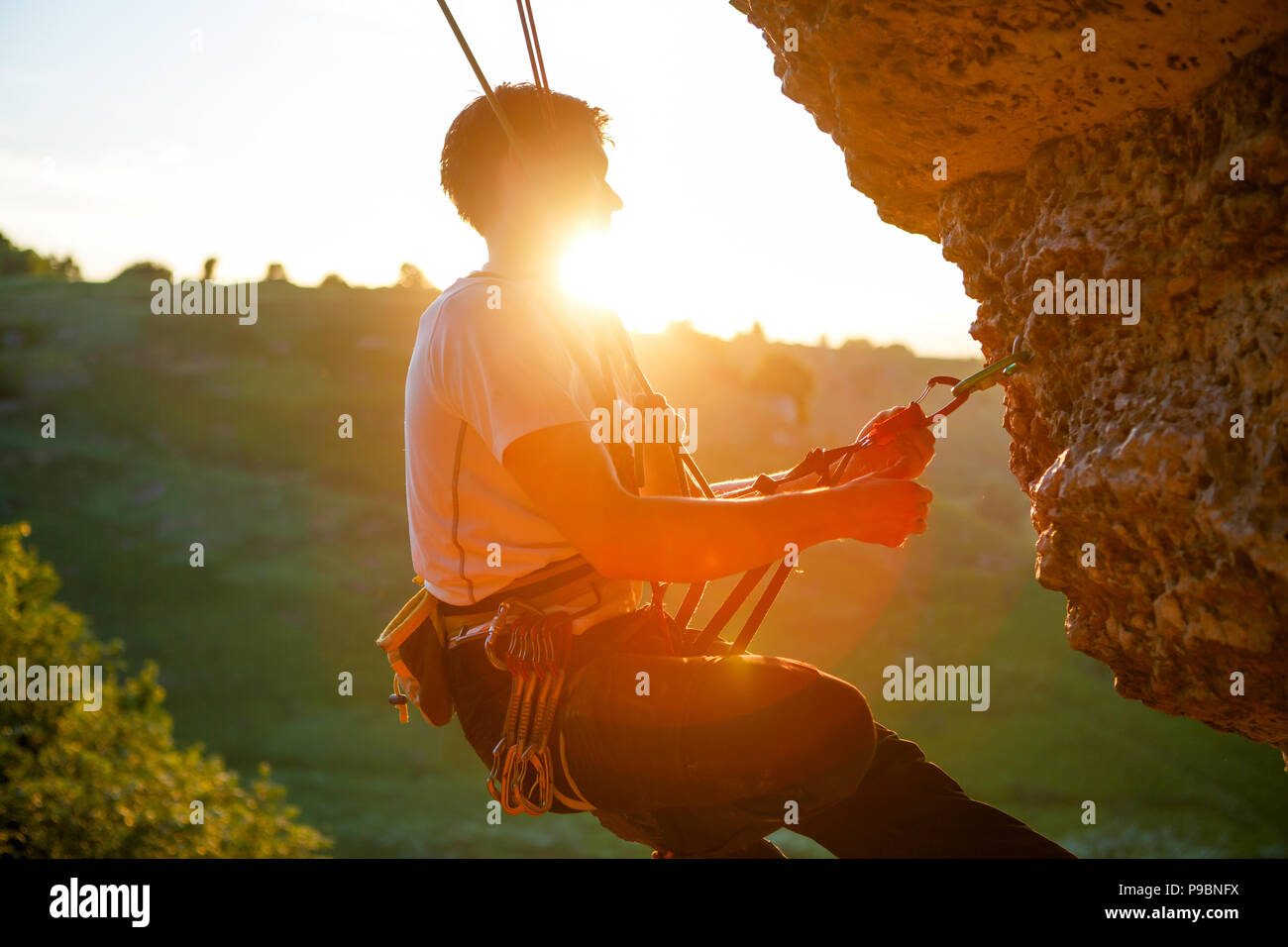 Picture of man clambering over rock Stock Photo - Alamy