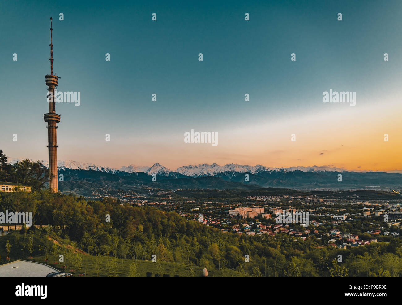 Sunset over the city of Almaty and a view of the Kok Tobe TV Tower ...