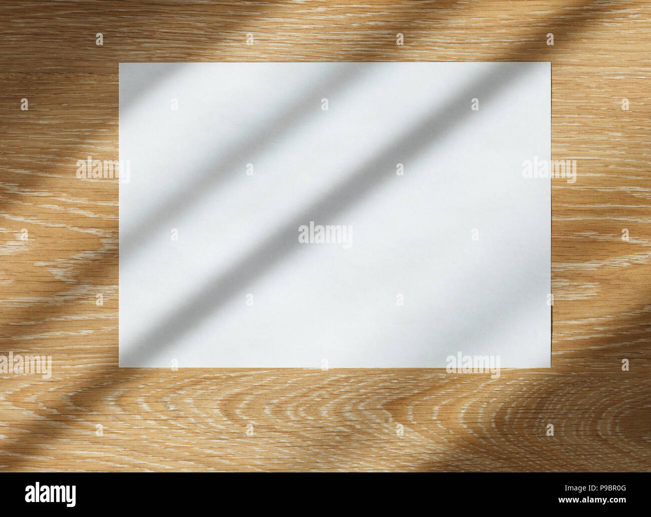 Blank sheet of paper landscape orientation on wooden background in sun ...