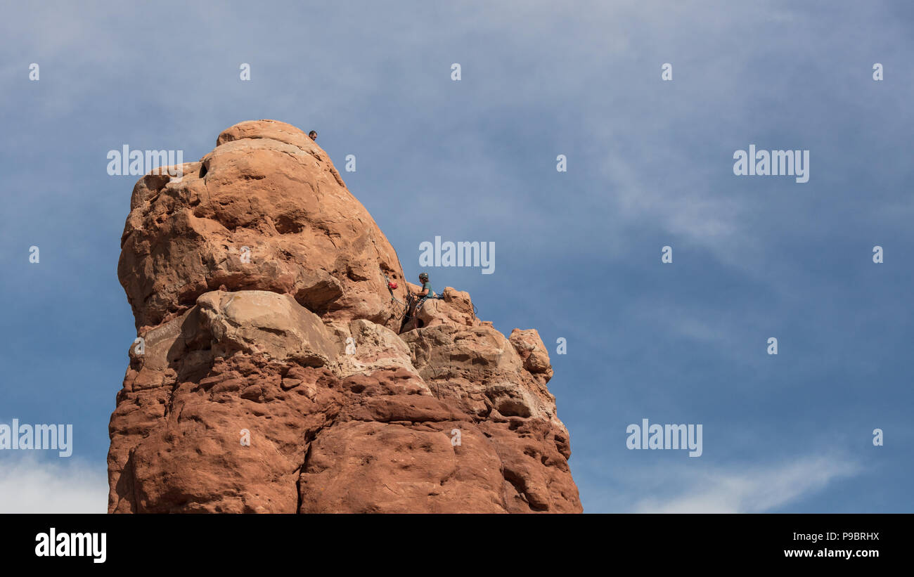 Rock climber scale up Owl Rock in Arches National Park in Utah Stock ...