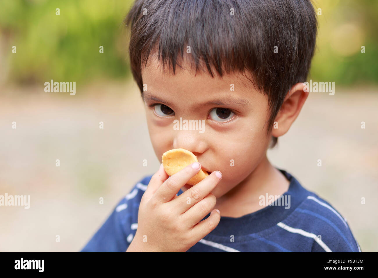 Asian little boy eating fish crisp Stock Photo - Alamy