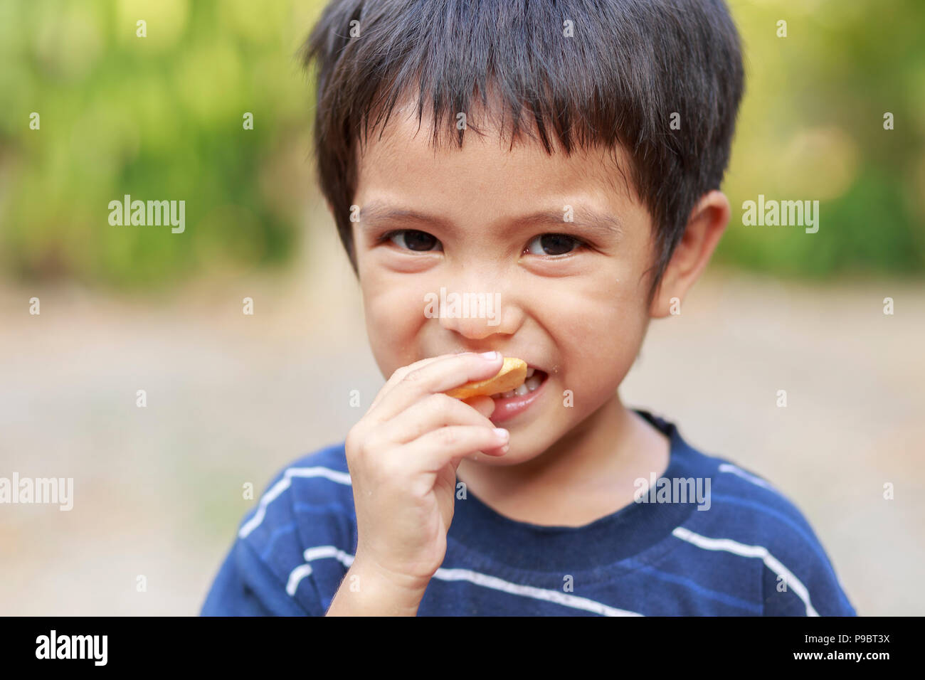 Asian little boy eating fish crisp Stock Photo - Alamy