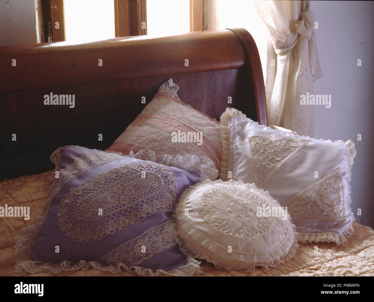 Pile of lace cushions on bed Stock Photo - Alamy