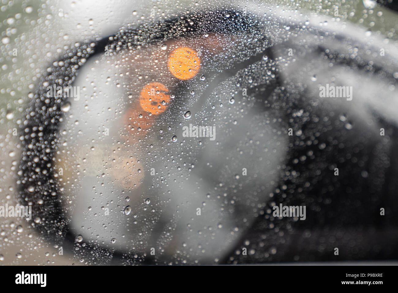 rain drops and car lights reflections through rear view mirror. summer ...