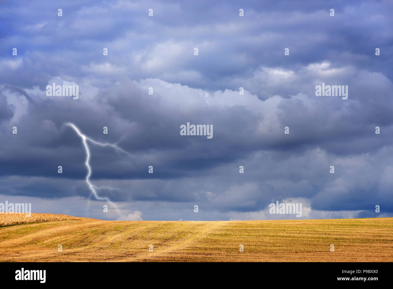 Dark storm clouds and lightning above autumn fields after harvesting ...
