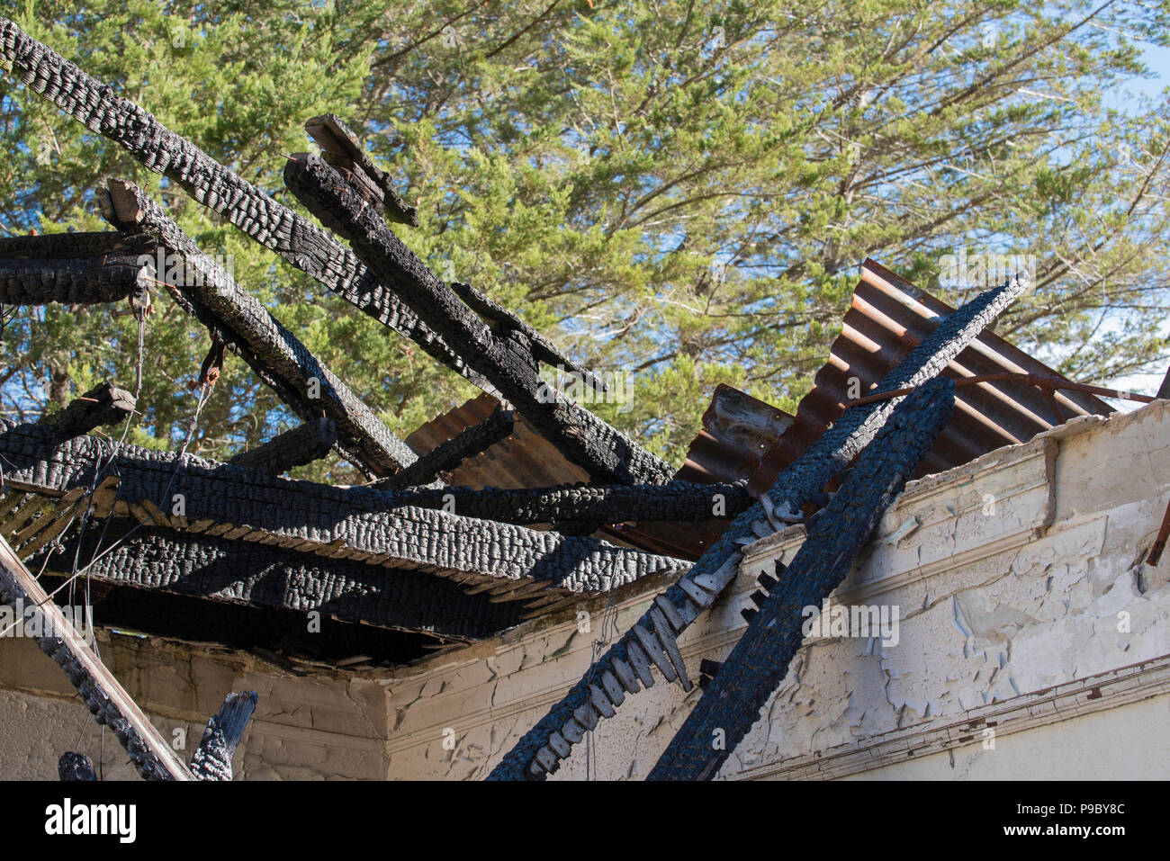 The charred timber beams of the burnt out roof of the old cottage at ...