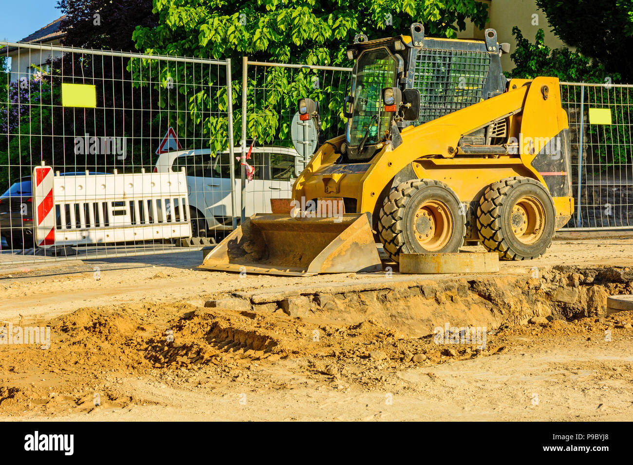 Orange dredger at a building site in the city. Construction of sewerage ...