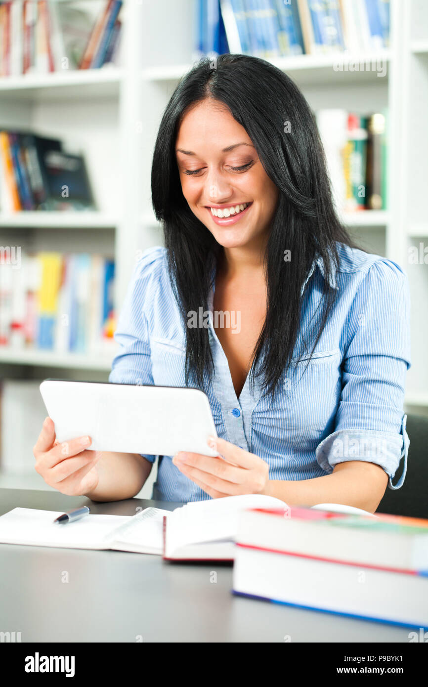 Happy student learning in library Stock Photo - Alamy