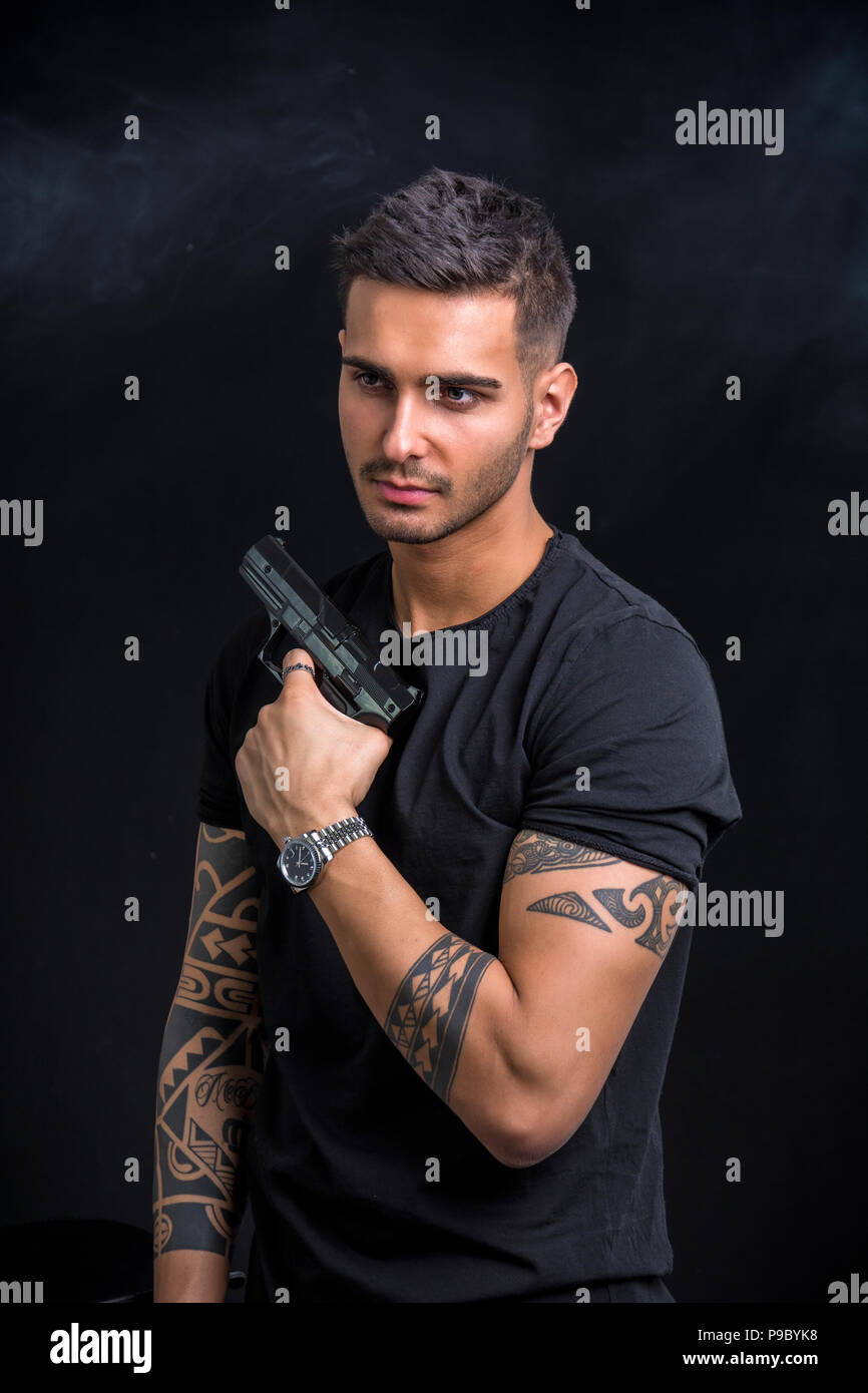 Young man holding hand gun Stock Photo - Alamy Young man holding hand gun Stock Photo - Alamy