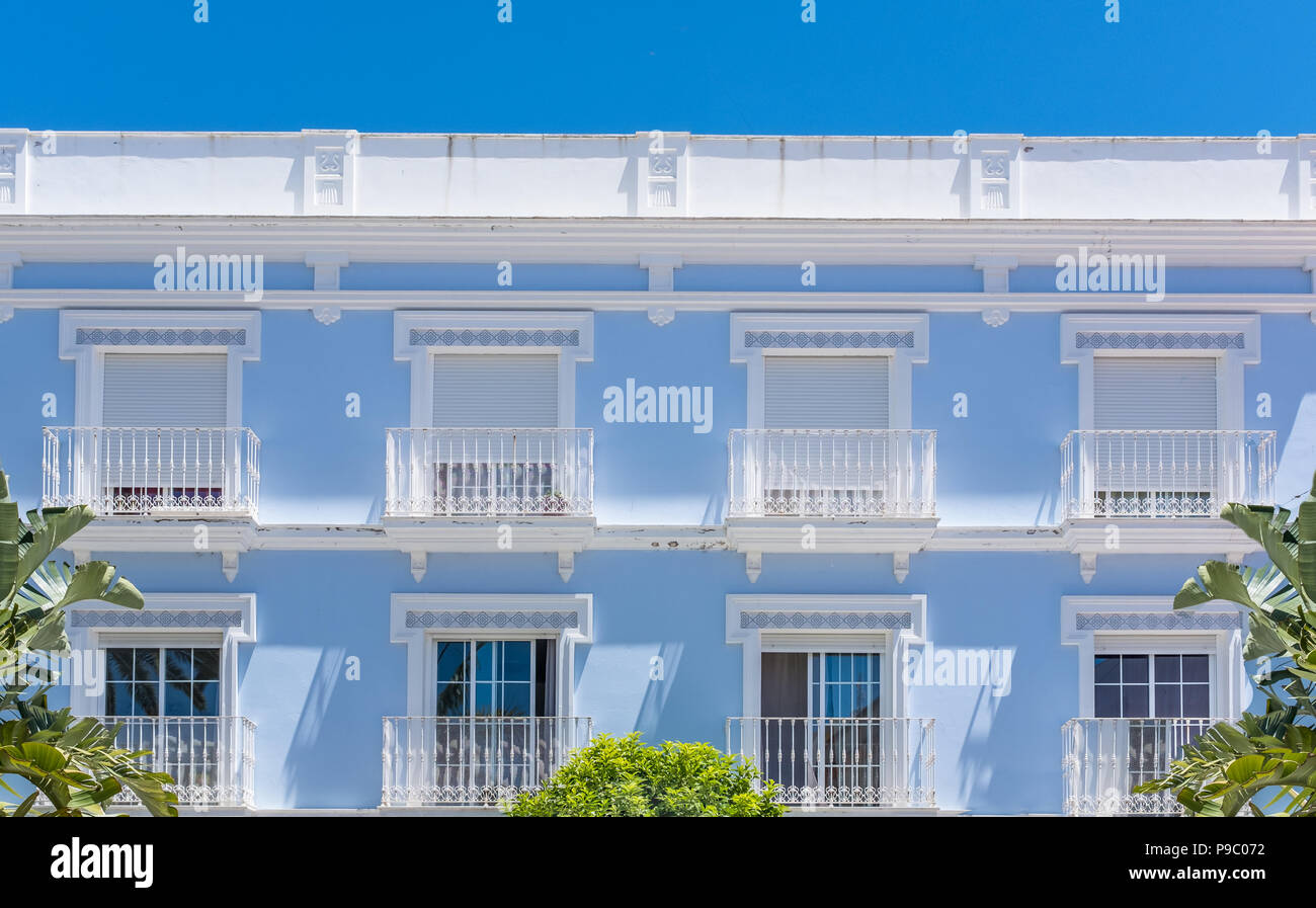 the facade of an elegant blue and white building against a blue sky ...