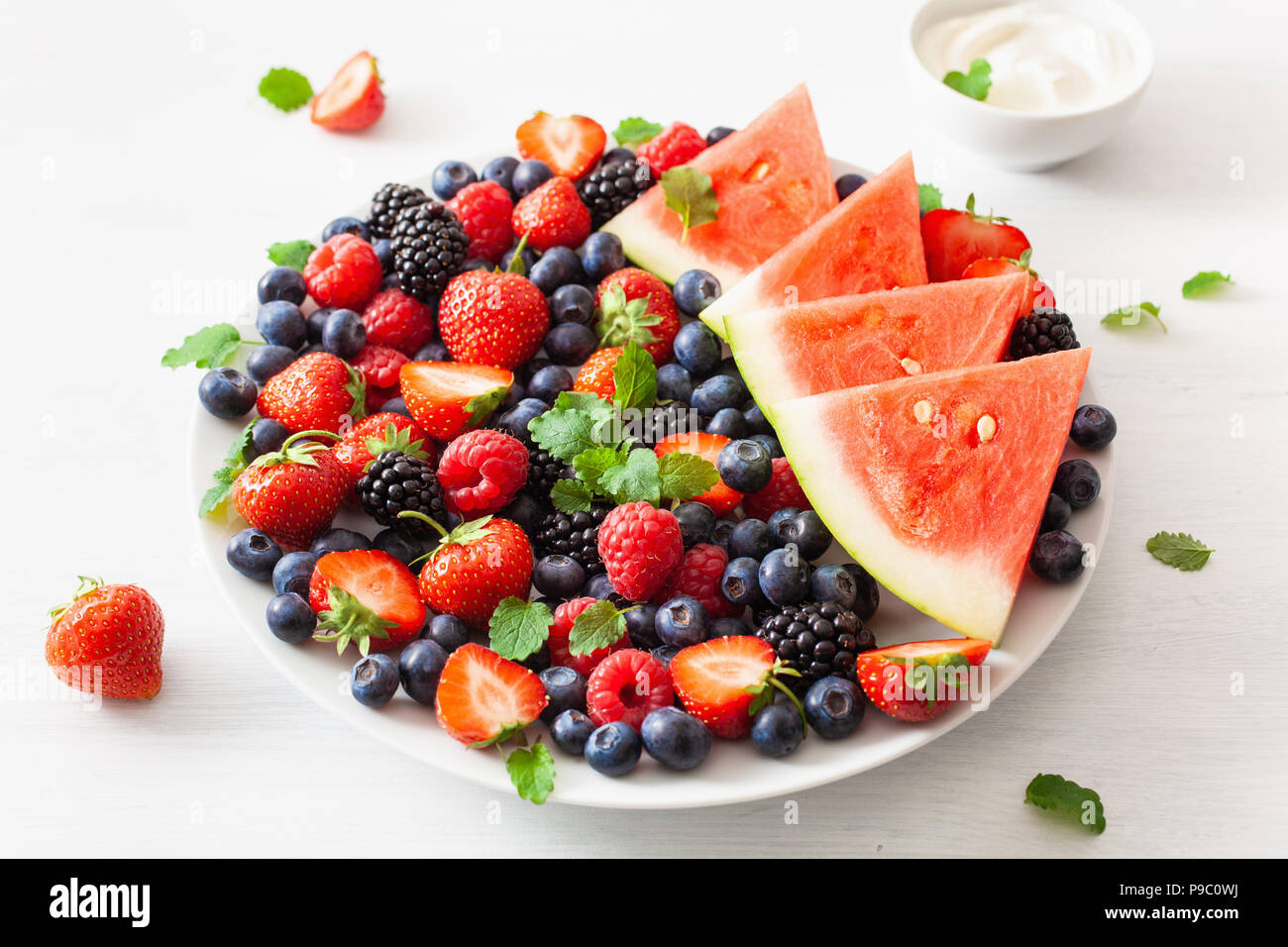 fruit and berry platter with yogurt over white. blueberry, strawberry ...