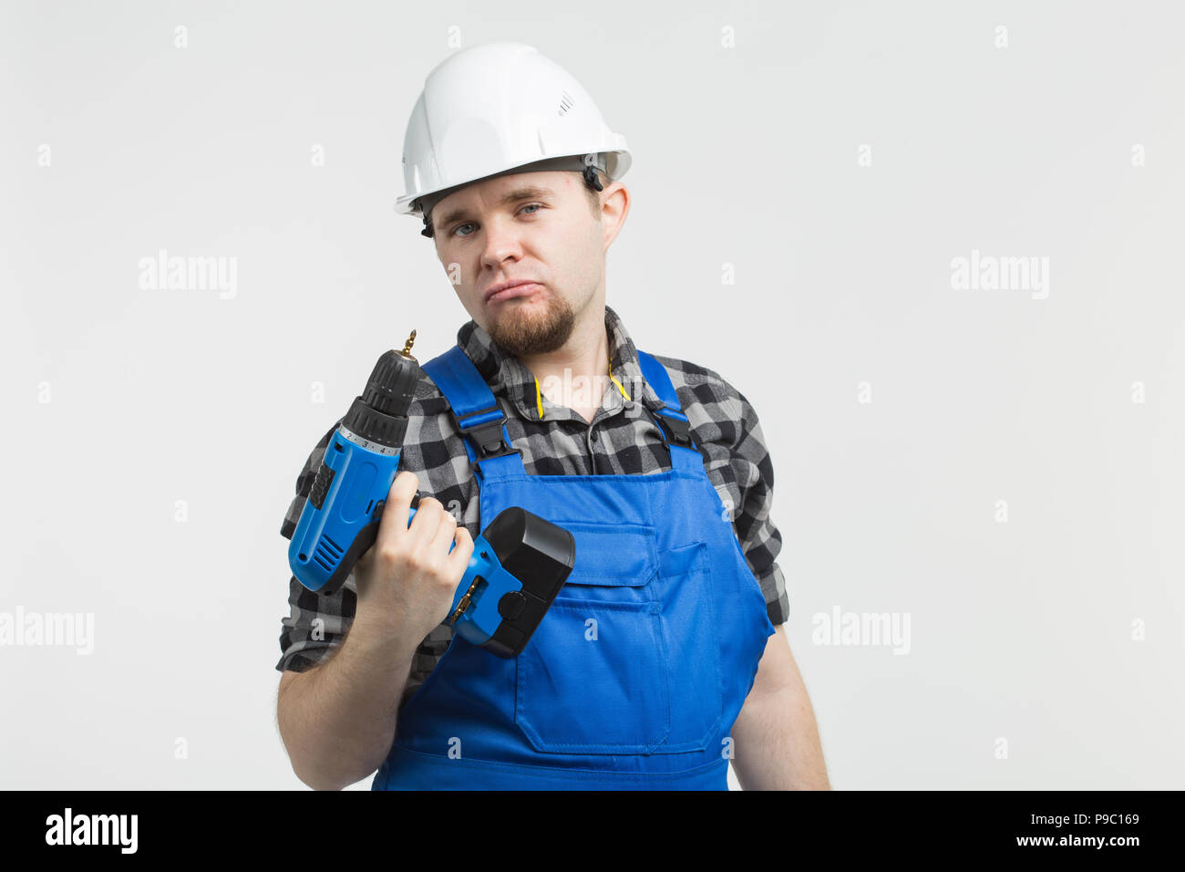 Funny builder standing with screwdriver on white background Stock Photo ...