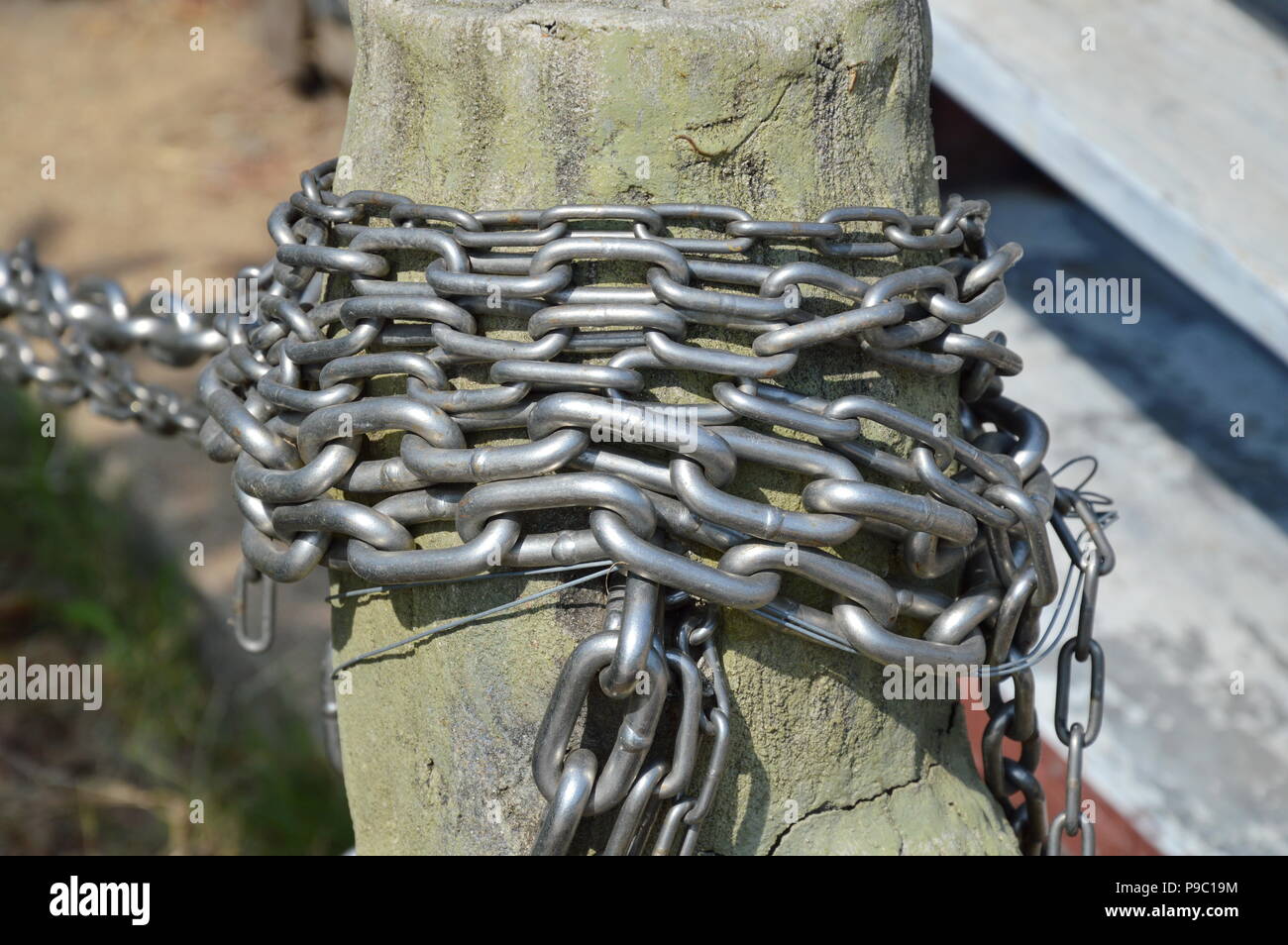 iron chain roll over wooden pole Stock Photo - Alamy