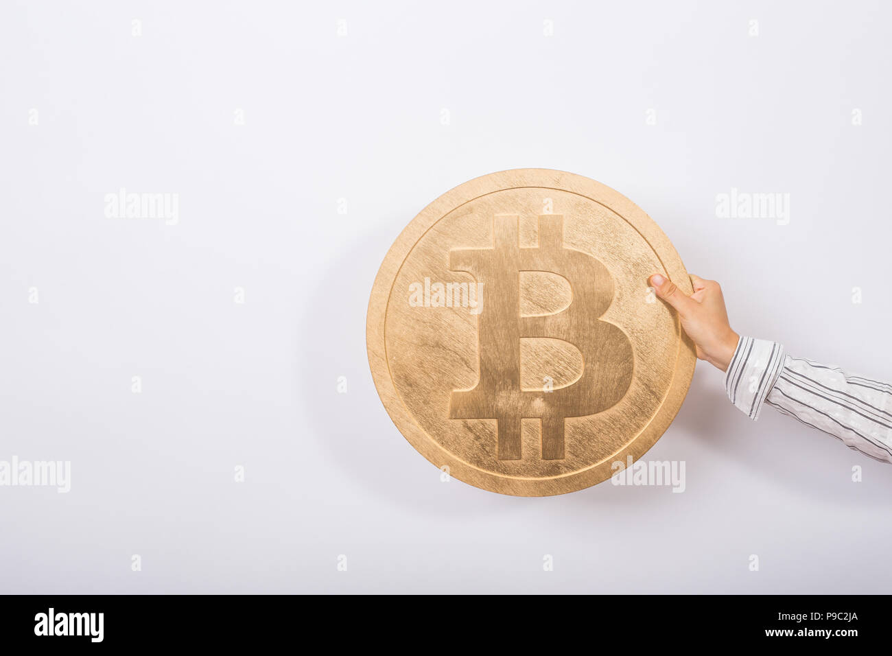 Big bitcoin in hand on white background. Virtual money, crypto currency ...
