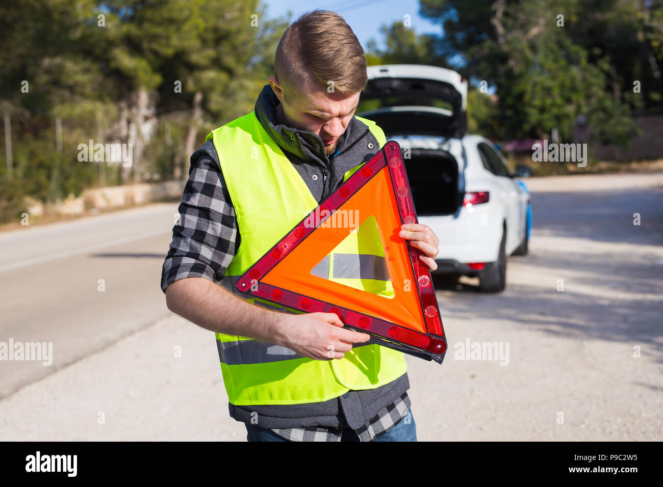 A man with a car gets an emergency sign Stock Photo - Alamy