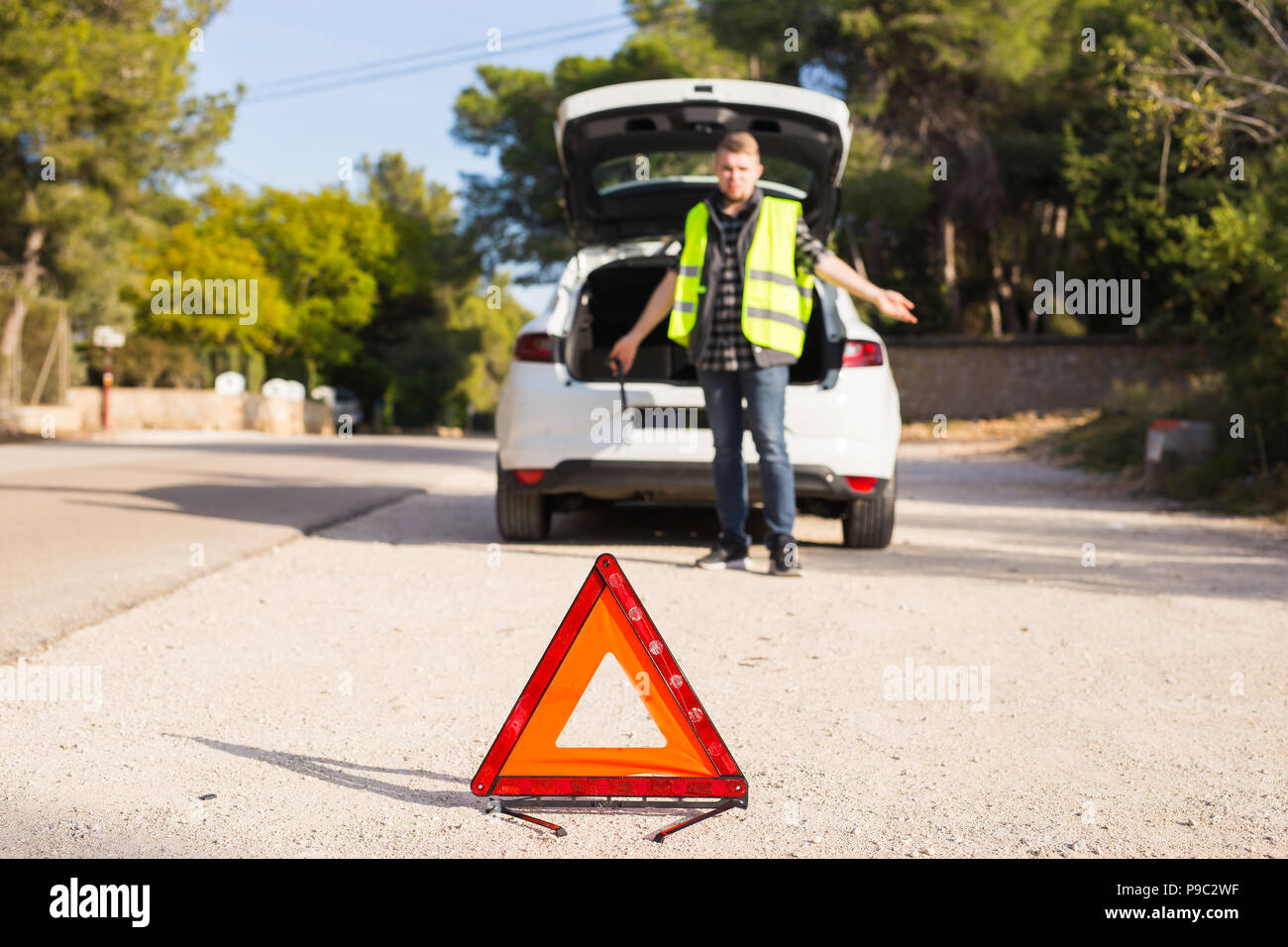 Red triangle man does not know what happened to the car Stock Photo - Alamy