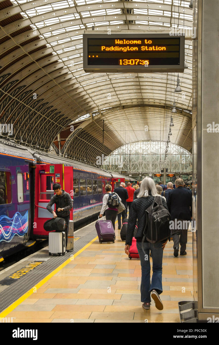 Passengers walking along a platform after getting off a train in London ...