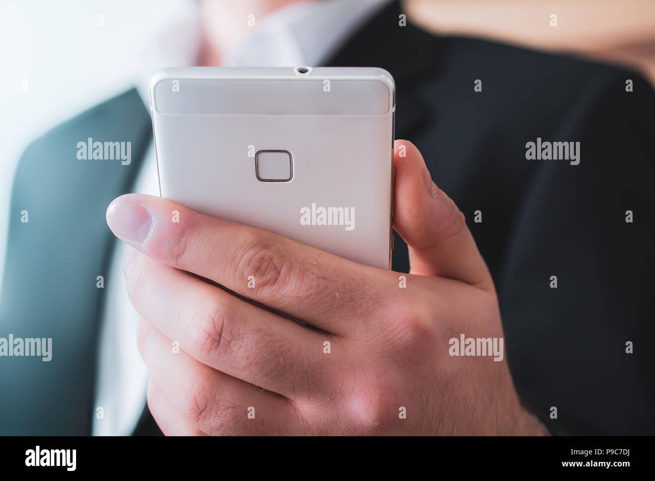 Backside Of A Smartphone, Holded By The Hand Of A Businessman In Suit ...