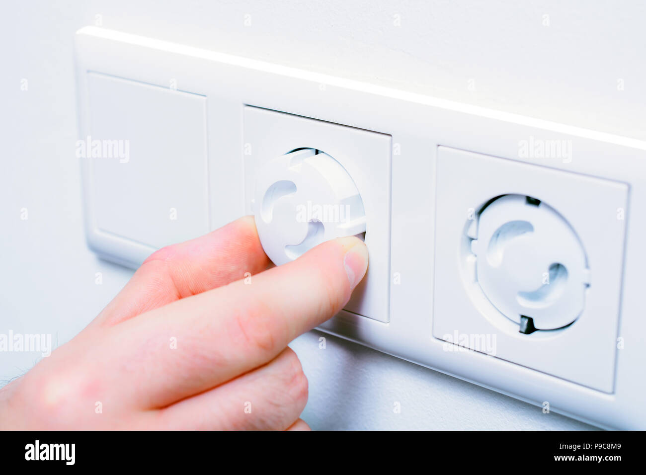 Inserting Baby Safety Plugs Into Wall Socket To Prevent Danger At Home ...